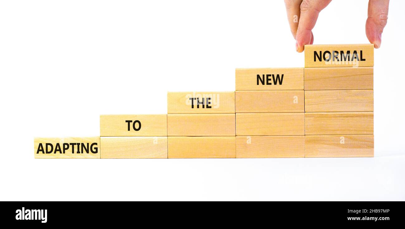 Adapting to the new normal symbol. Wooden blocks with words Adapting to ...
