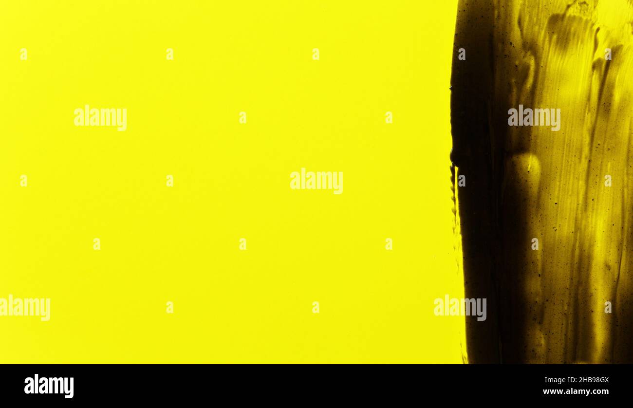 Abstract black smears (charcoal toothpaste) on yellow background, space ...