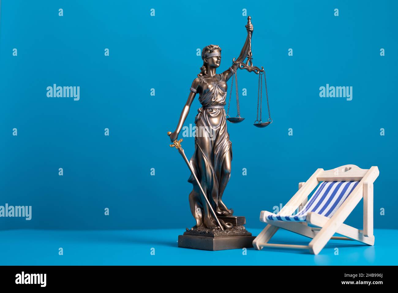 Statue of a woman with scales as the symbol of law and justice ona blue ...