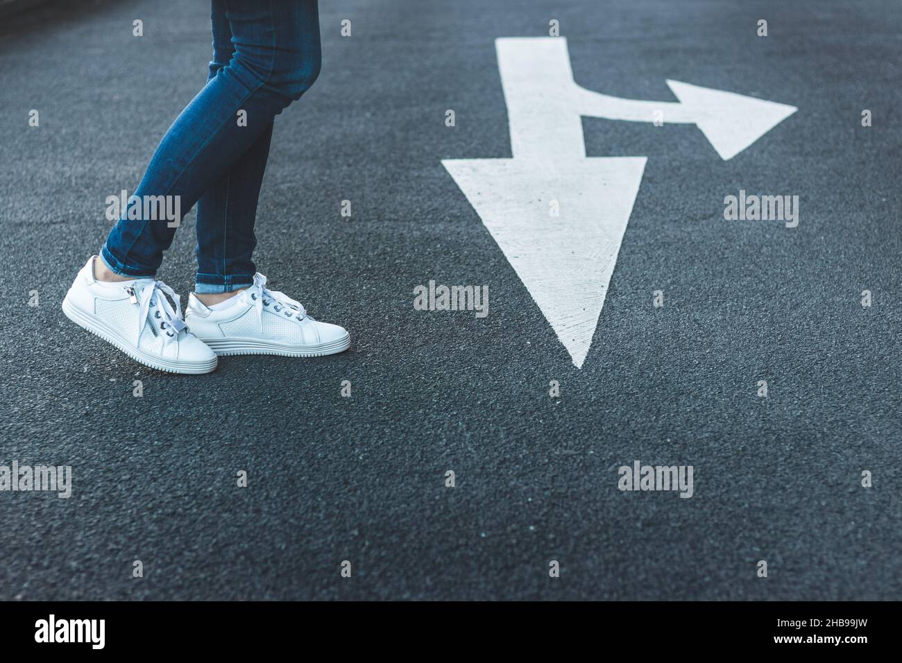 Make decision which way to go. Directional sign on road and legs with ...