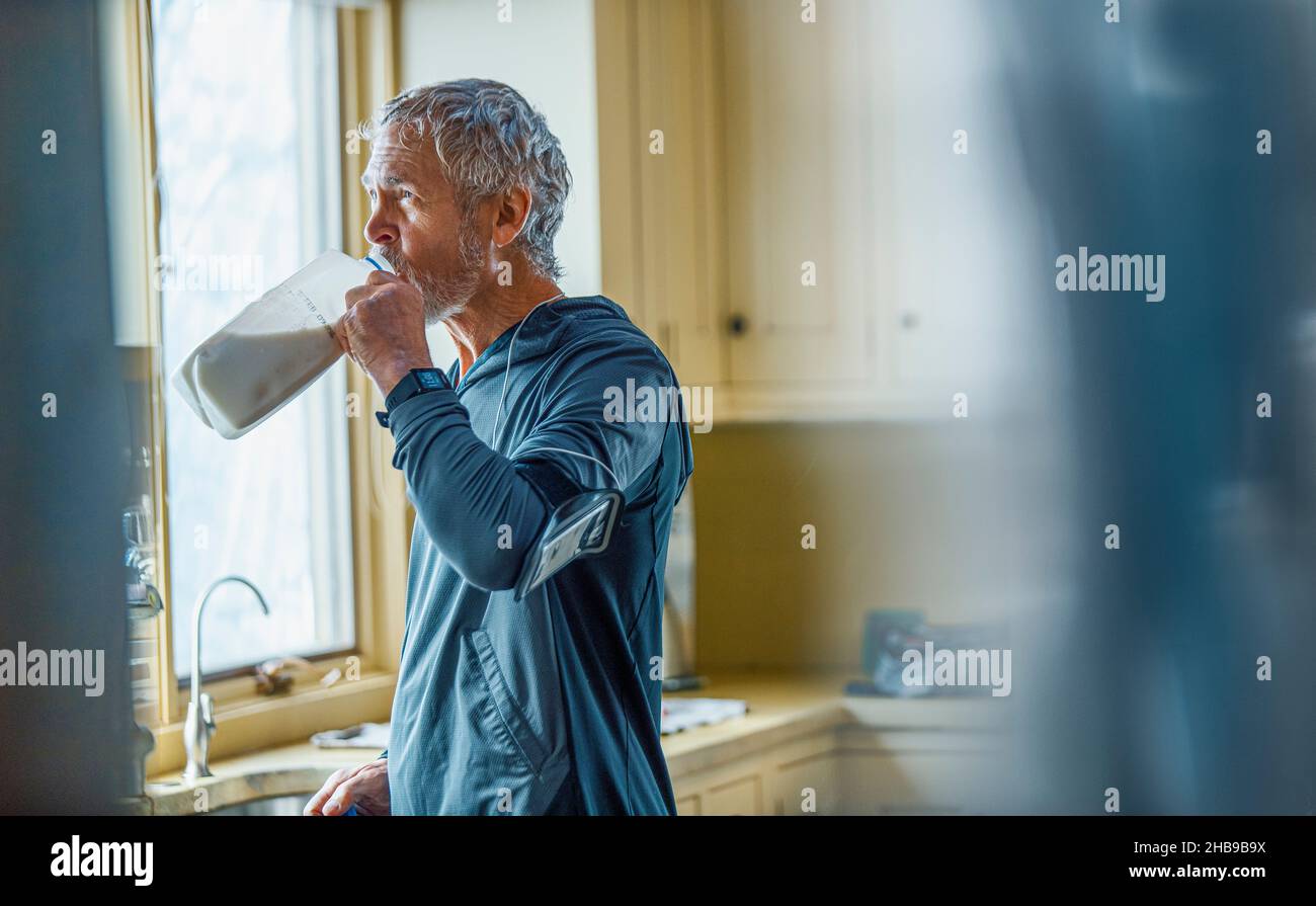 Senior man drinking milk in his kitchen after a run Stock Photo - Alamy
