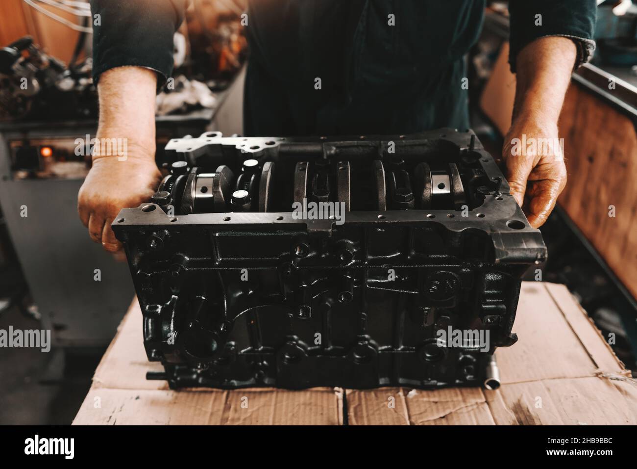 Auto mechanic adjusting cylinder head on engine block at workshop Stock ...