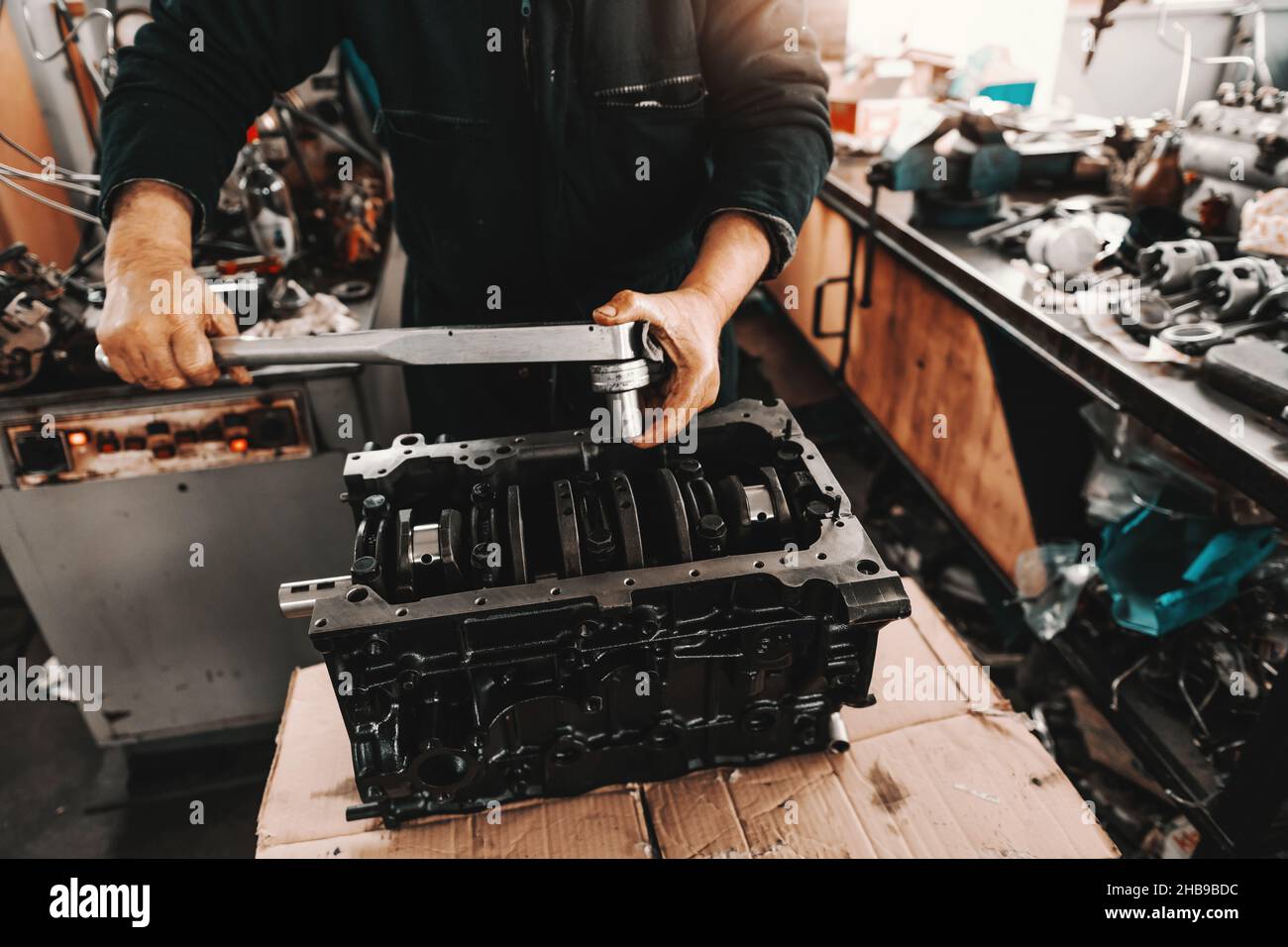 Auto mechanic adjusting cylinder head on engine block with wrench at ...