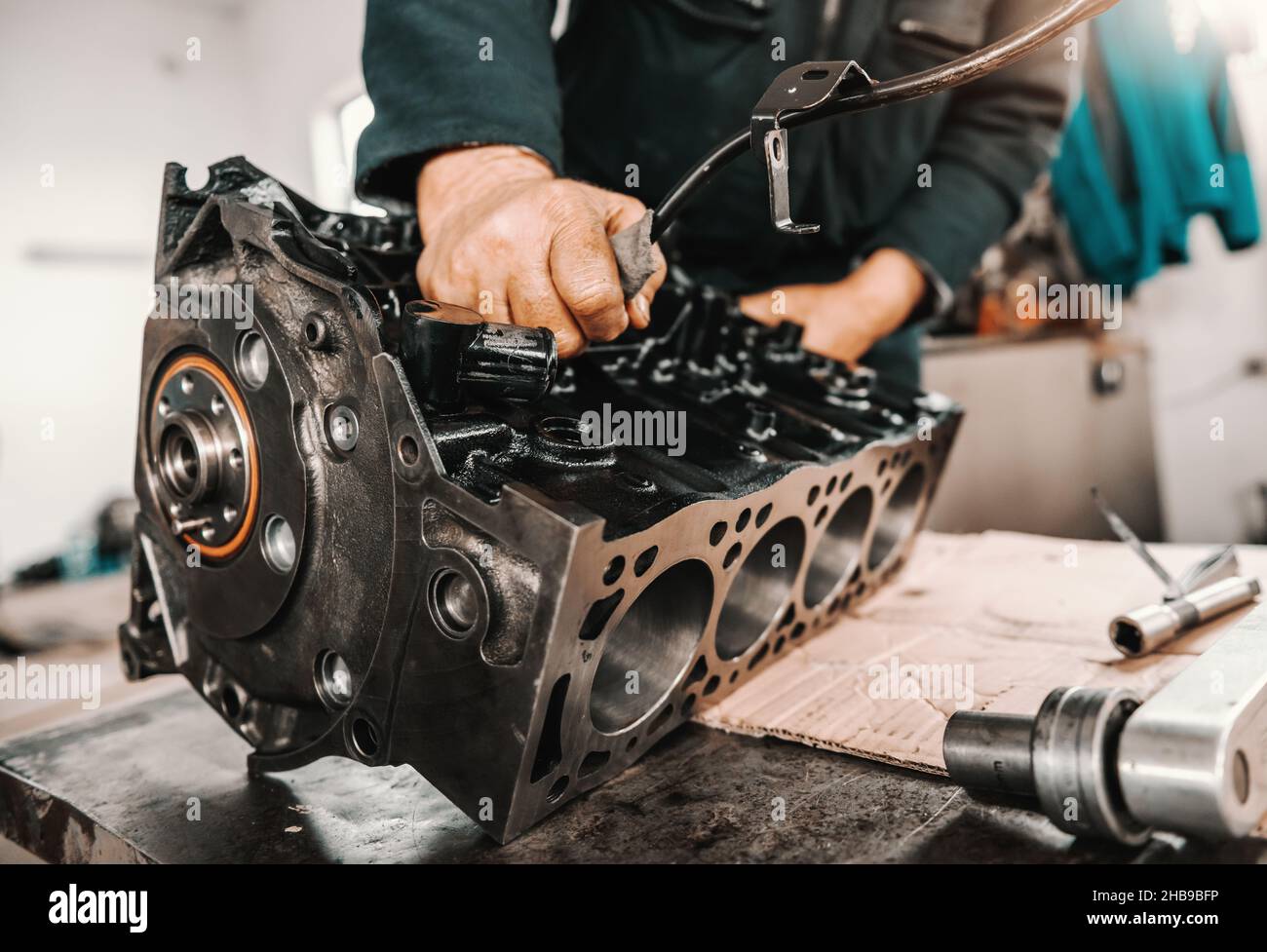 Auto mechanic adjusting cylinder head on engine block at workshop Stock ...