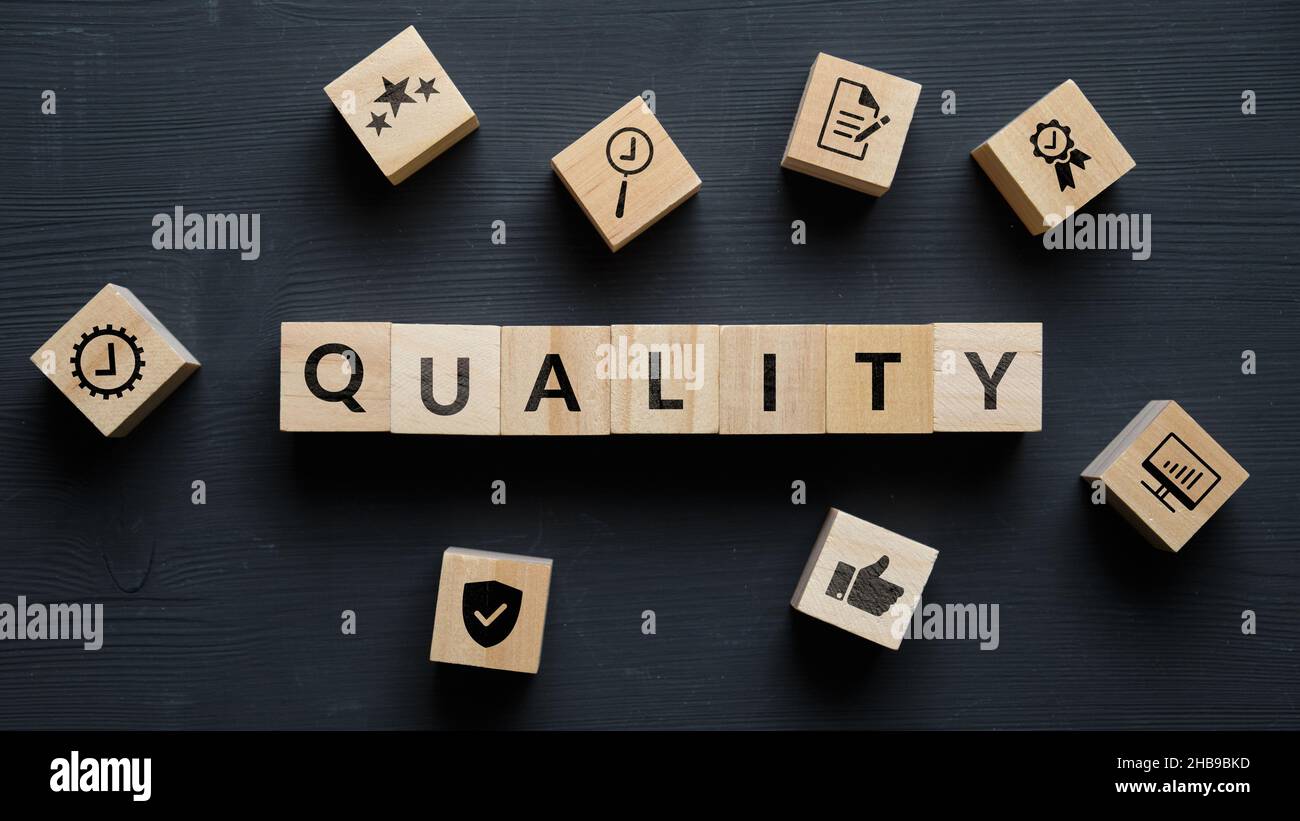 Quality concept with themed icons on wooden cubes Stock Photo - Alamy