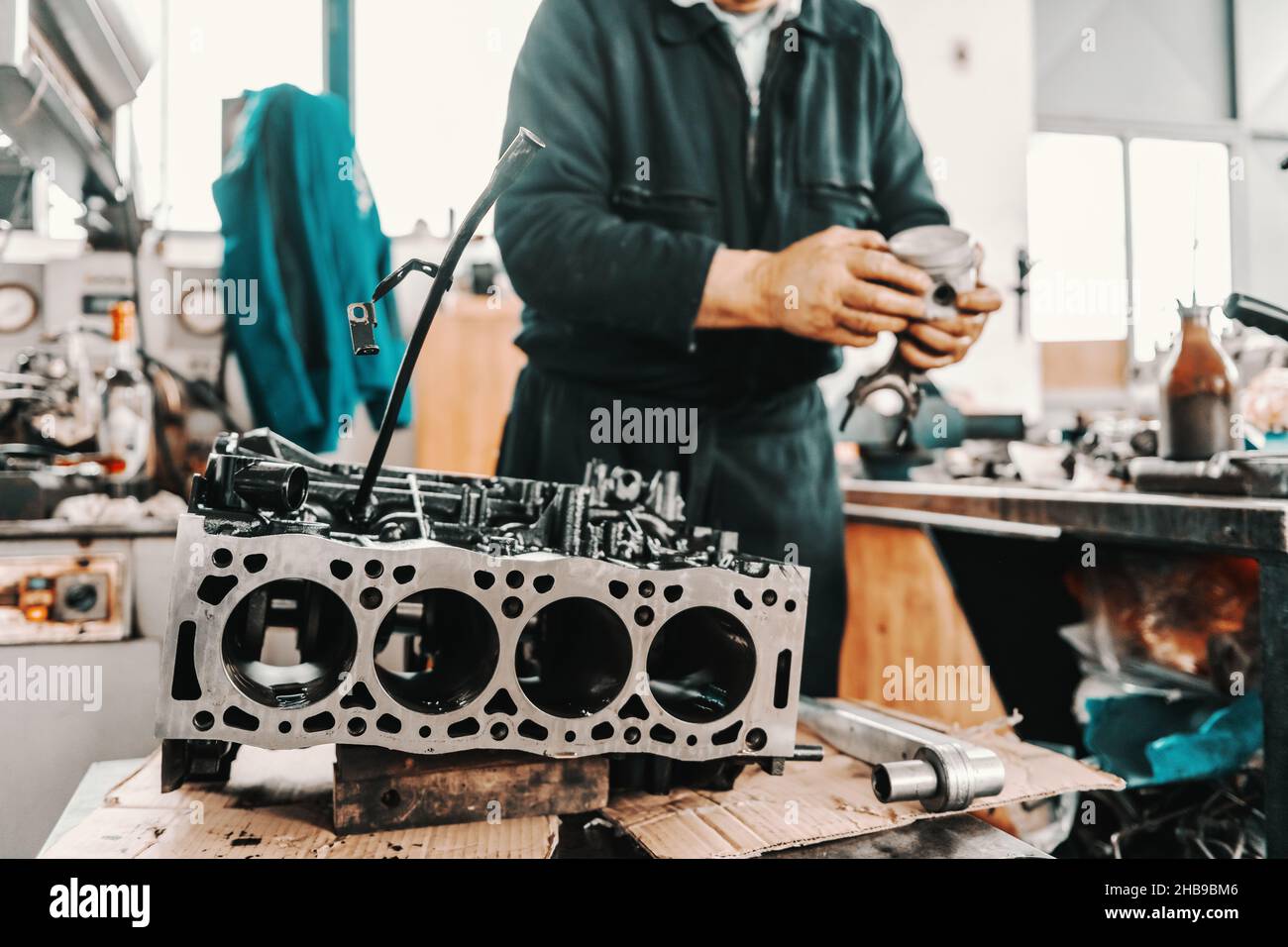 Auto mechanic adjusting cylinder from engine block at workshop Stock ...