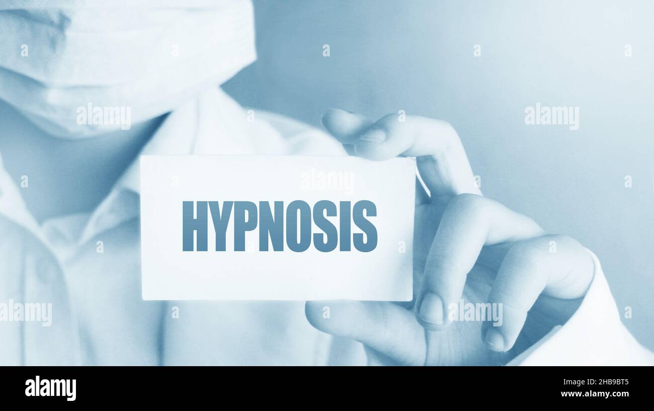 Hypnosis word written on a card in doctor's hand. Alternative therapy ...