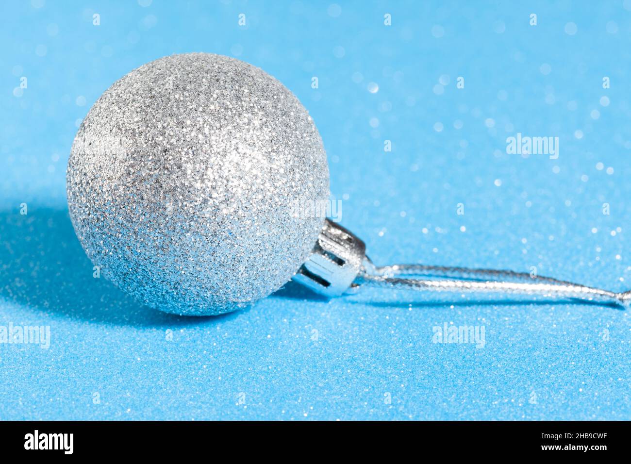 silver shiny christmas ball on sparkling blue background Stock Photo ...