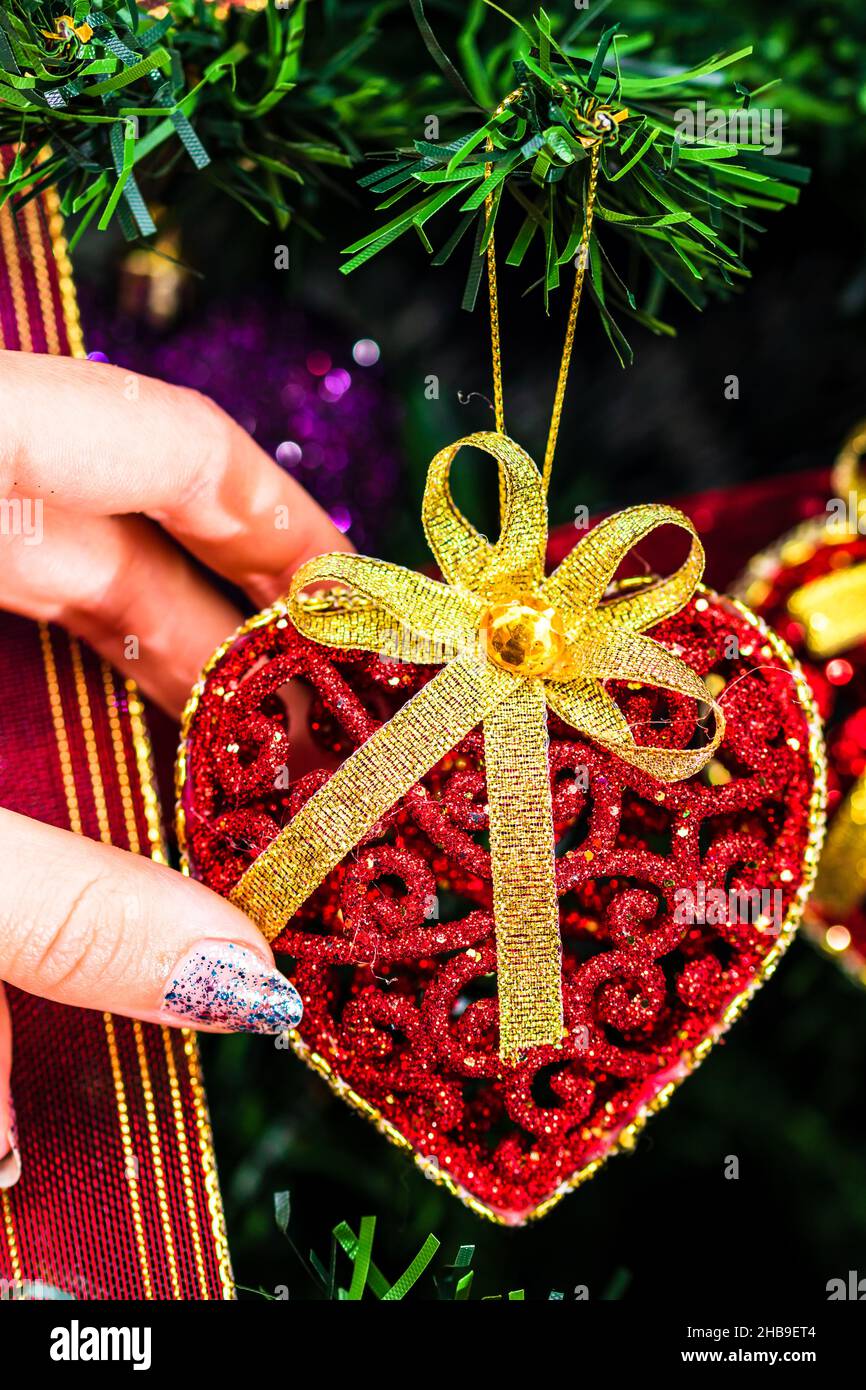 Decorating Christmas tree, hand putting Christmas decorations on fir ...