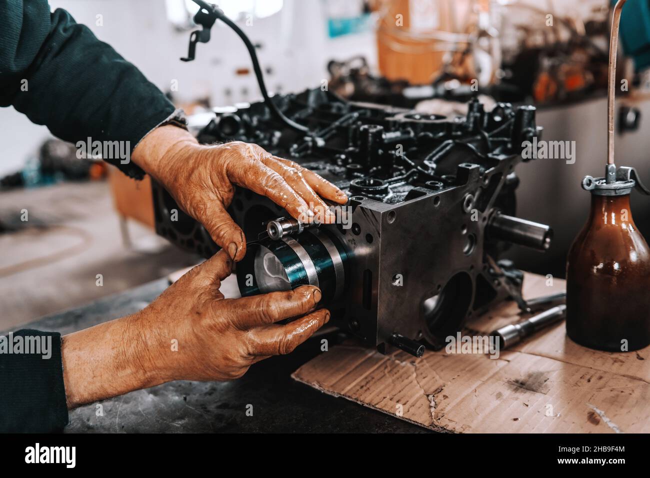 Auto mechanic adjusting cylinder on engine block at workshop Stock ...