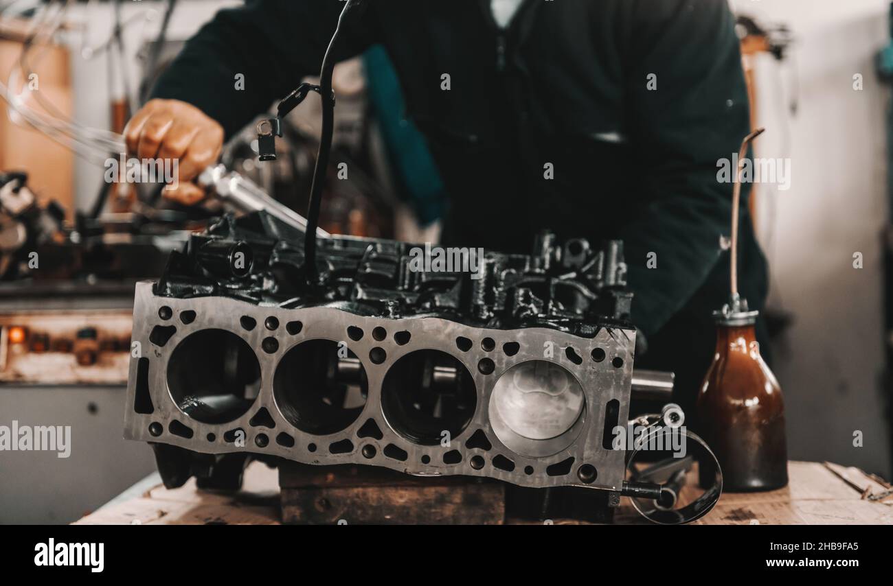 Auto mechanic adjusting cylinder head on engine block with wrench at ...