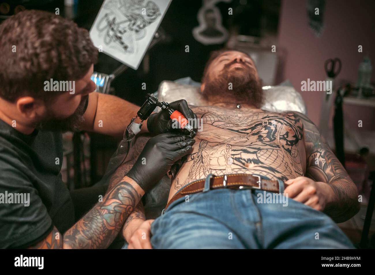 Tattooist doing tattoo picture in tattoo studio Stock Photo - Alamy