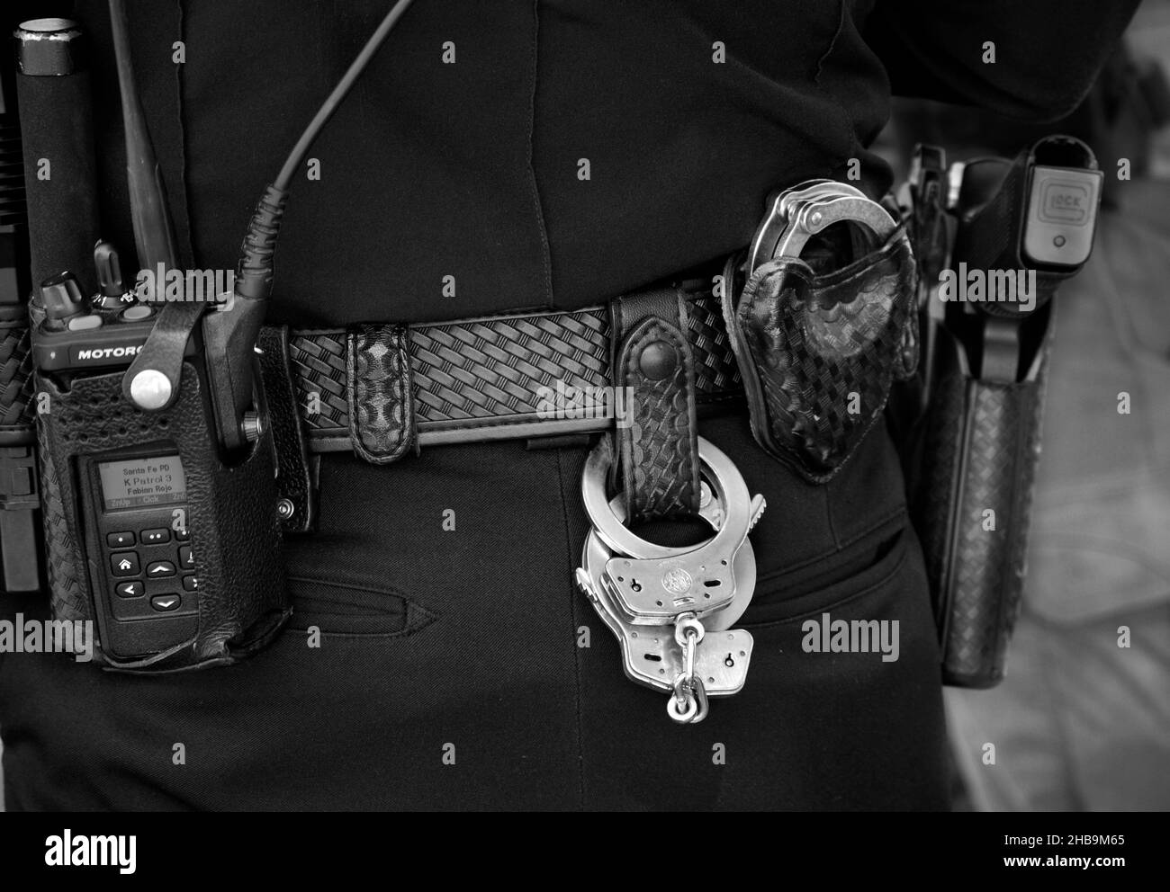 Police officers wearing belts equipped with handguns, handcuffs, radio ...
