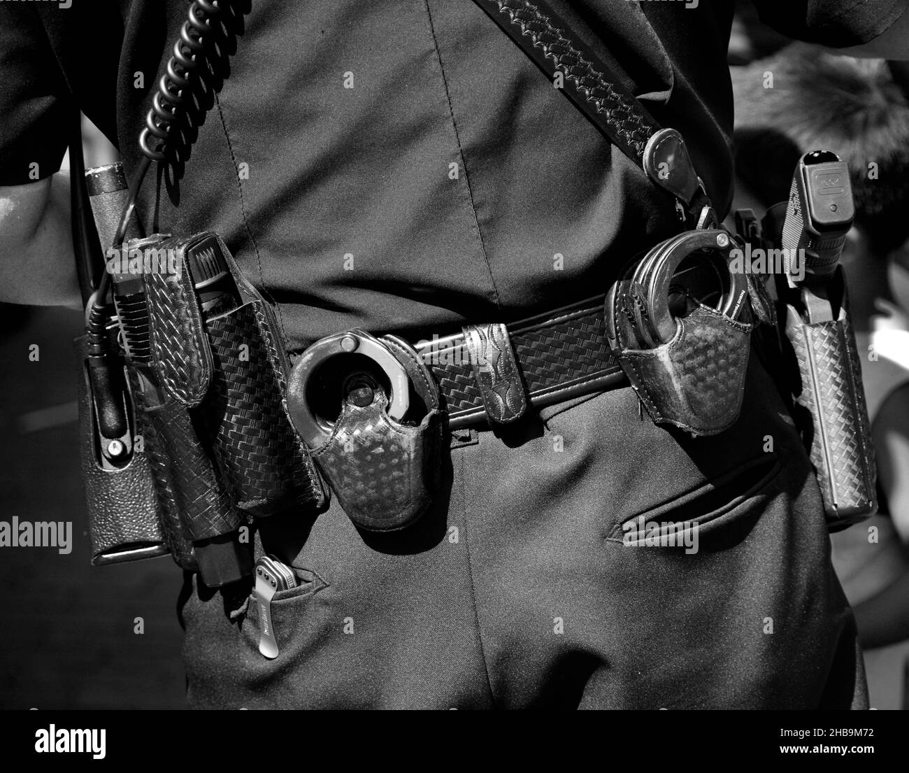 Police officers wearing belts equipped with handguns, handcuffs, radio ...