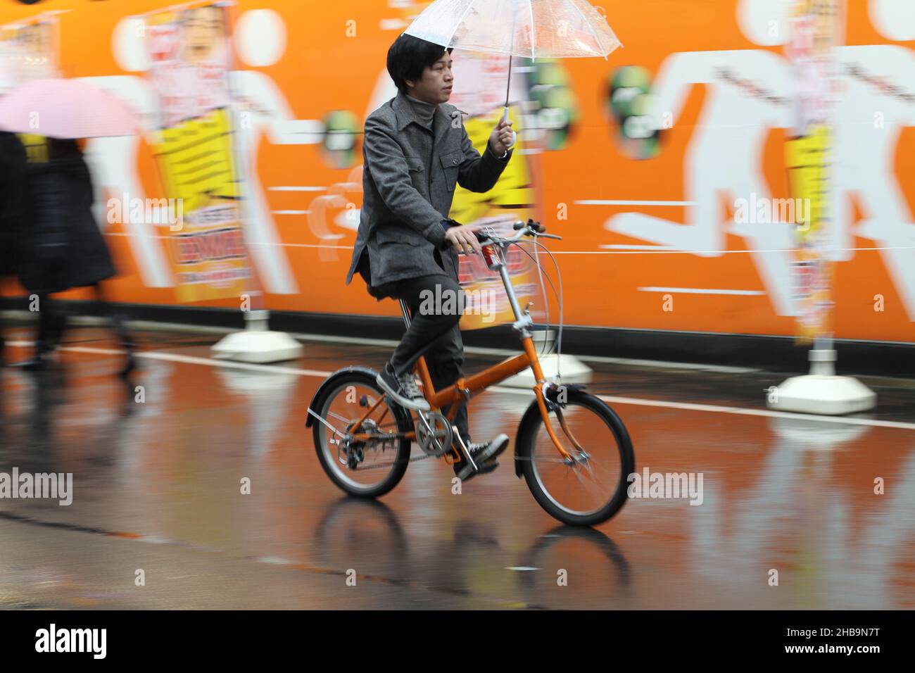 Cyclist in the rain with umbrella hi-res stock photography and images ...