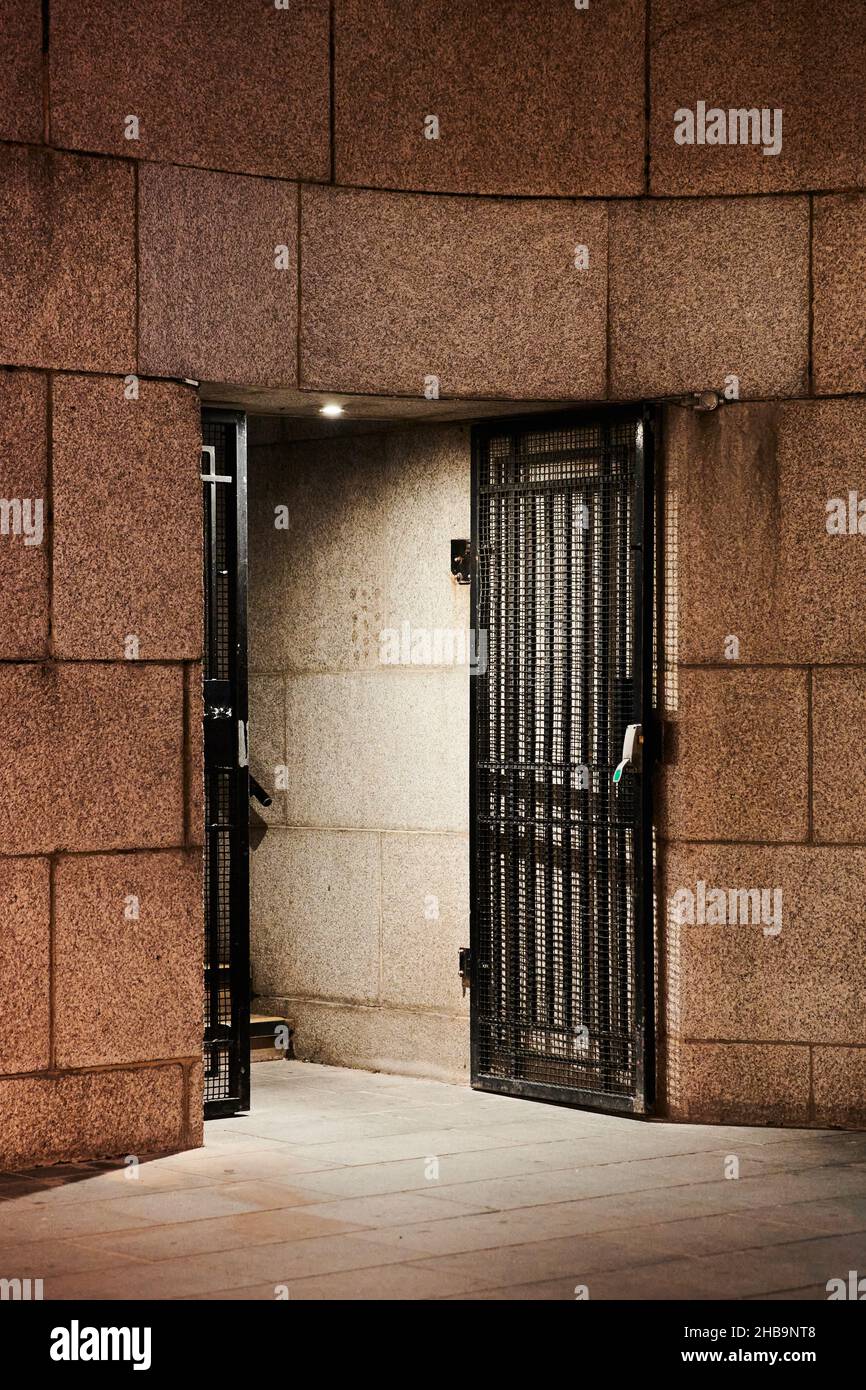 High contrast image of black metal gateway in marble block wall Stock ...