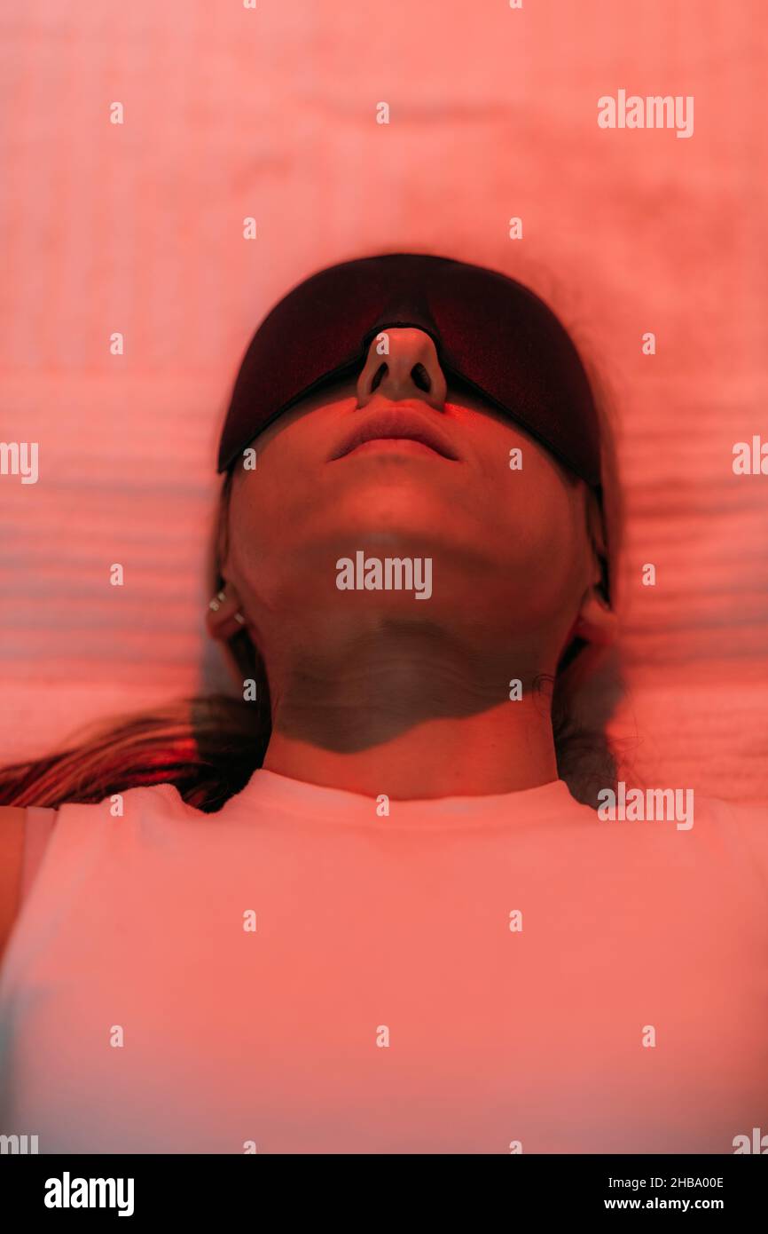 Colour light therapy. Female face under the red light Stock Photo - Alamy