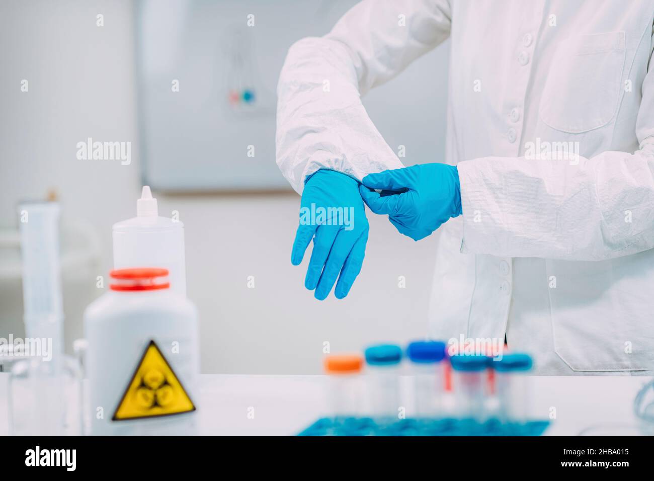 Lab technician putting on protective clothing Stock Photo - Alamy
