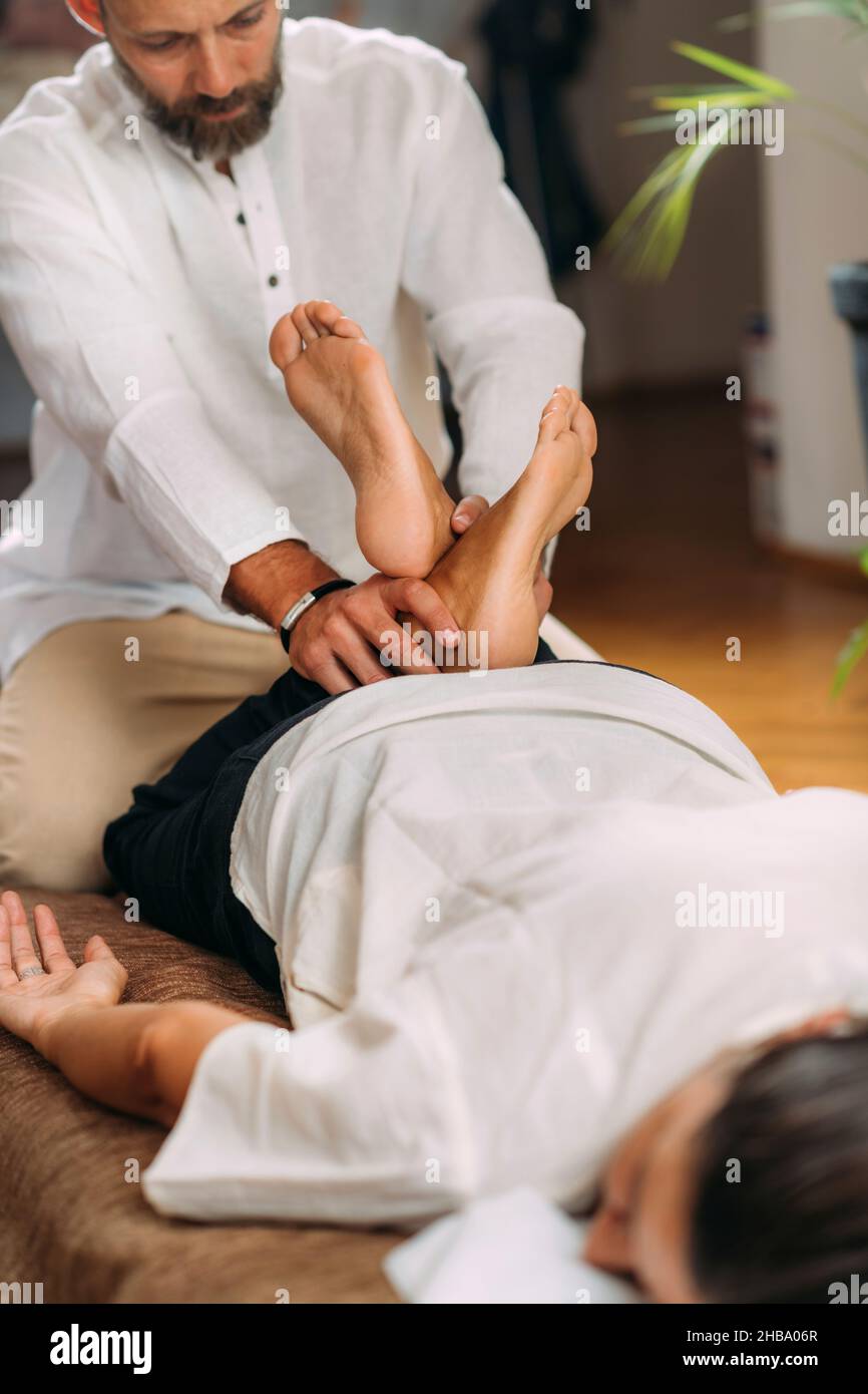 Therapist stretching woman's back during shiatsu massage Stock Photo ...