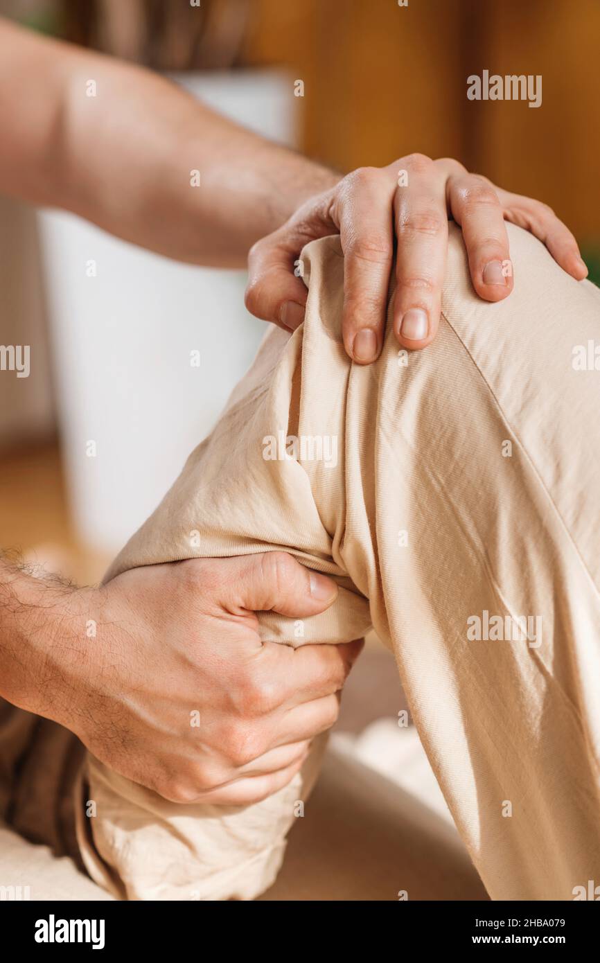 Traditional Thai leg massage. Thai masseur performing relaxing passive ...