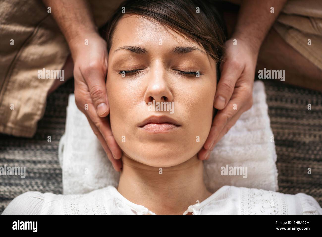 Thai face massage. Thai massage therapist holding hands over client's ...