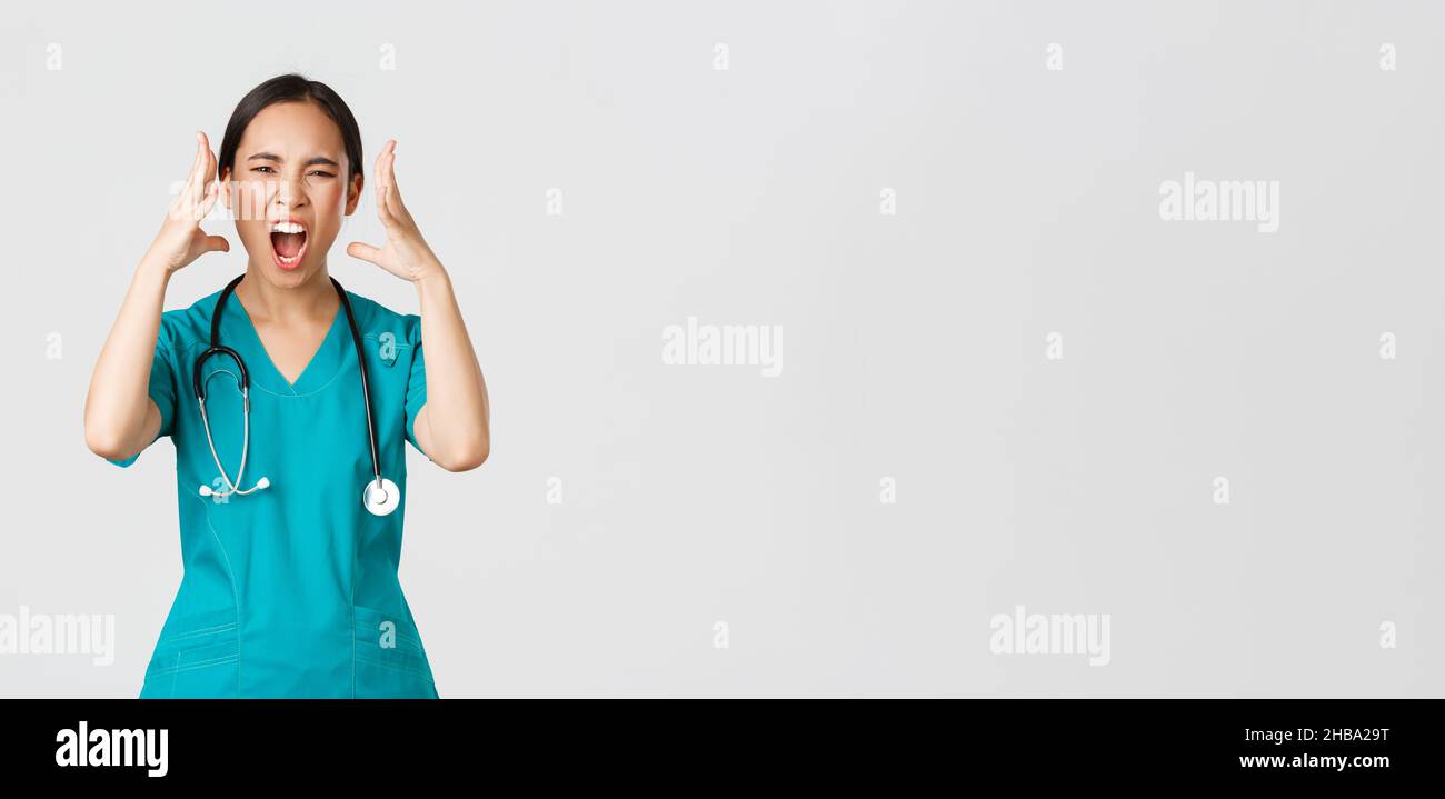 Covid-19, healthcare workers and preventing virus concept. Annoyed and ...