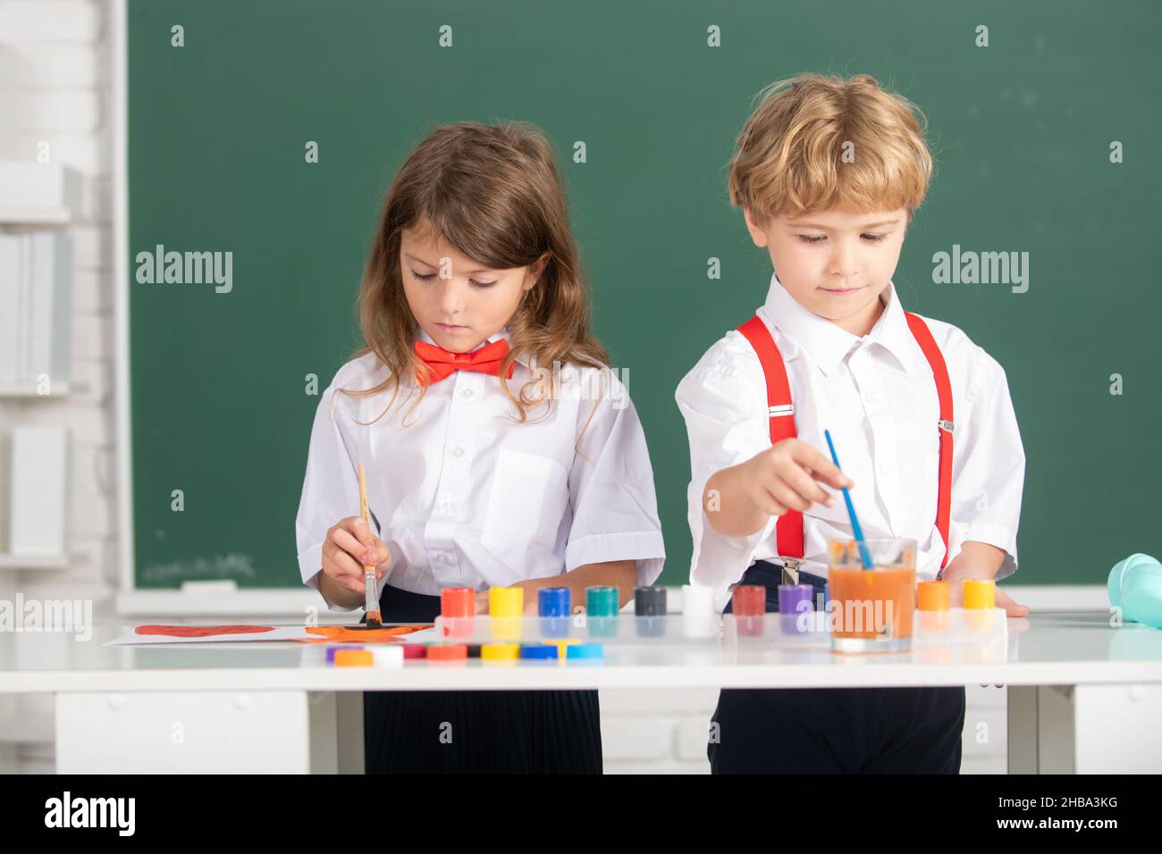 Cute school friends kids drawing and painting at school. Friendly boy ...