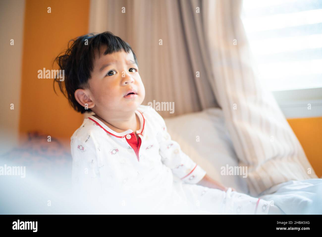 Cute toddler baby boy waking up stretching crying is upset looking away ...