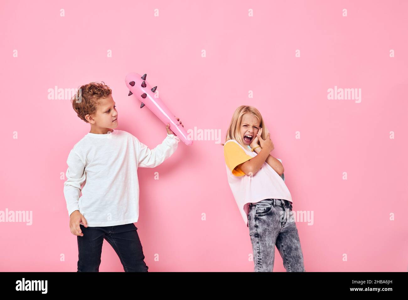 a boy with a toy baton beats a girl Stock Photo - Alamy
