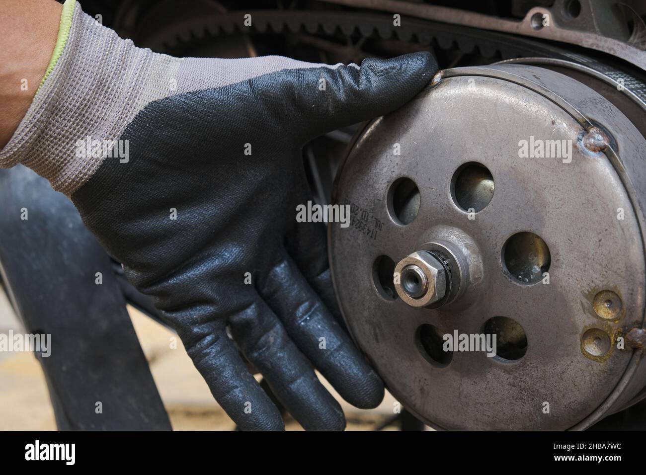 Scooter motorcycle CVT gear and clutch repair hand of mechanic close up ...