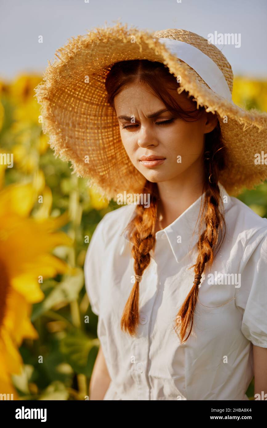 woman with two pigtails in a straw hat in a white dress a field of ...