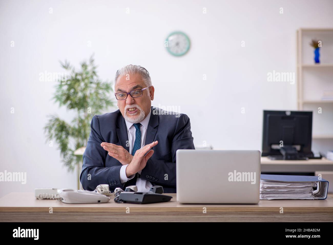 Old businessman employee speaking on the phone in the office Stock ...