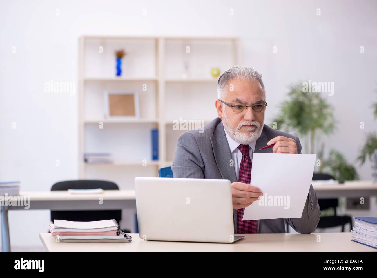 Old employee working in the office Stock Photo - Alamy