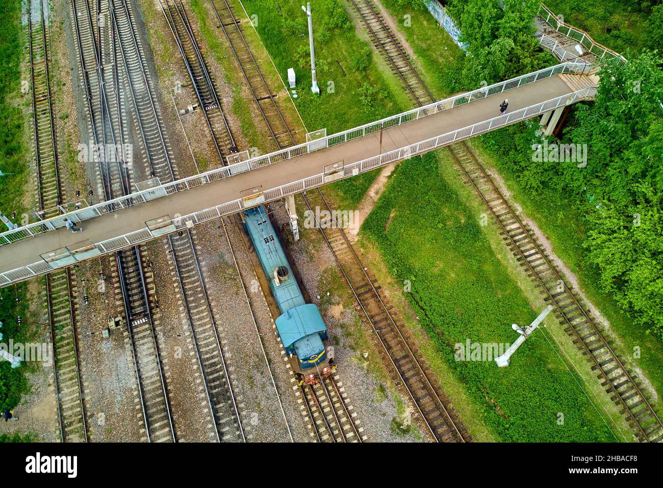 Pedestrian bridge over the railroad tracks and trolley, view from above ...