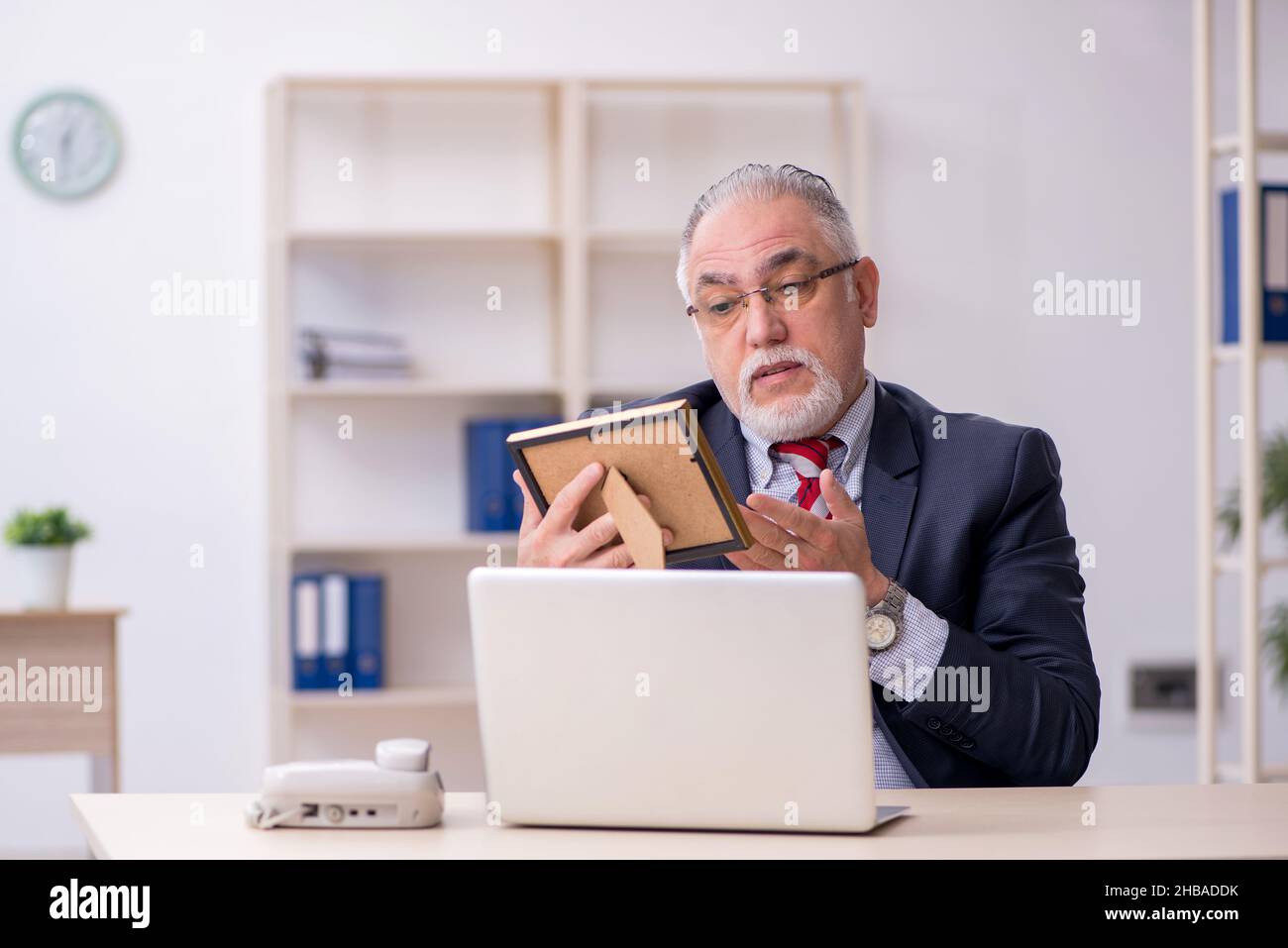 Old businessman employee missing wife at workplace Stock Photo - Alamy