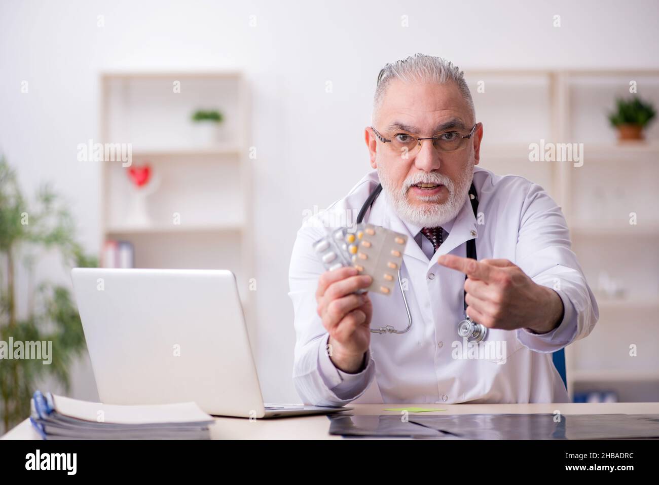 Old doctor working in the clinic Stock Photo - Alamy