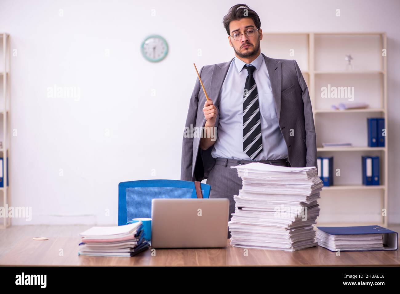 Funny young employee magician and too much work in the office Stock ...