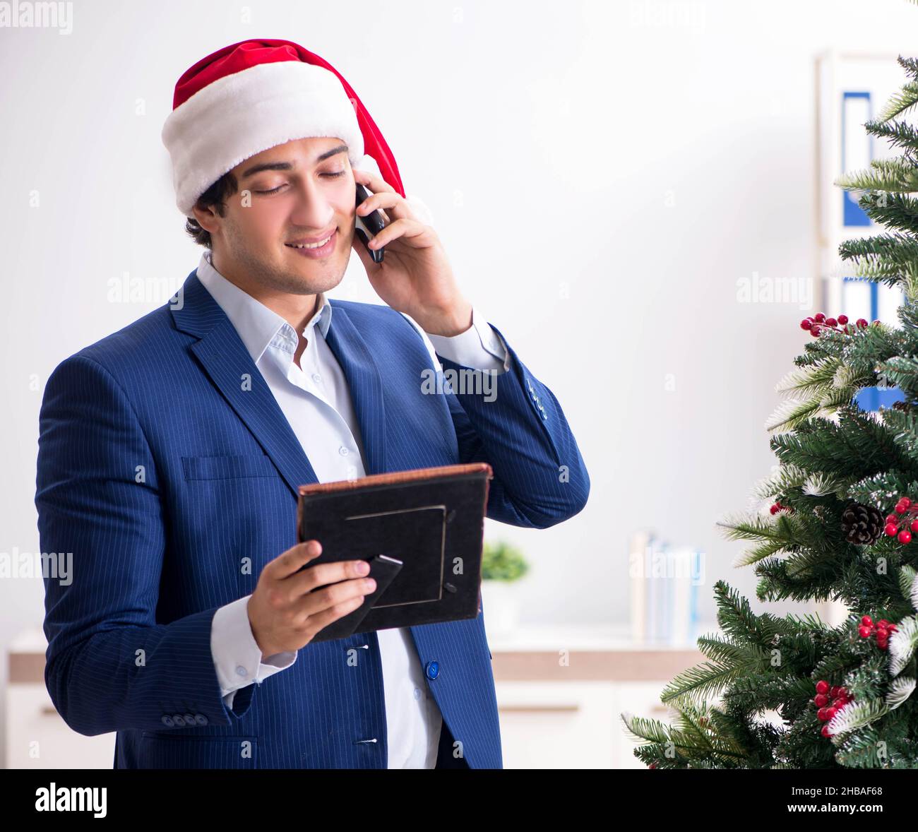 The young employee celebrating christmas at workplace Stock Photo - Alamy