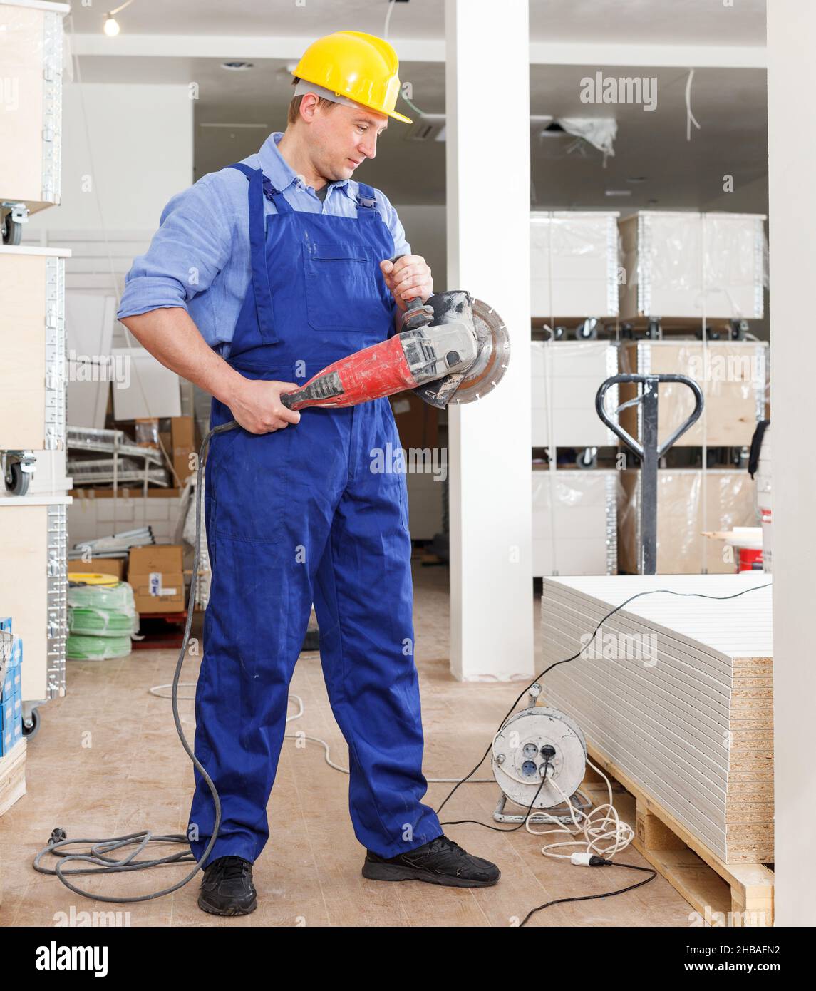Builder working with handheld disc grinder Stock Photo - Alamy