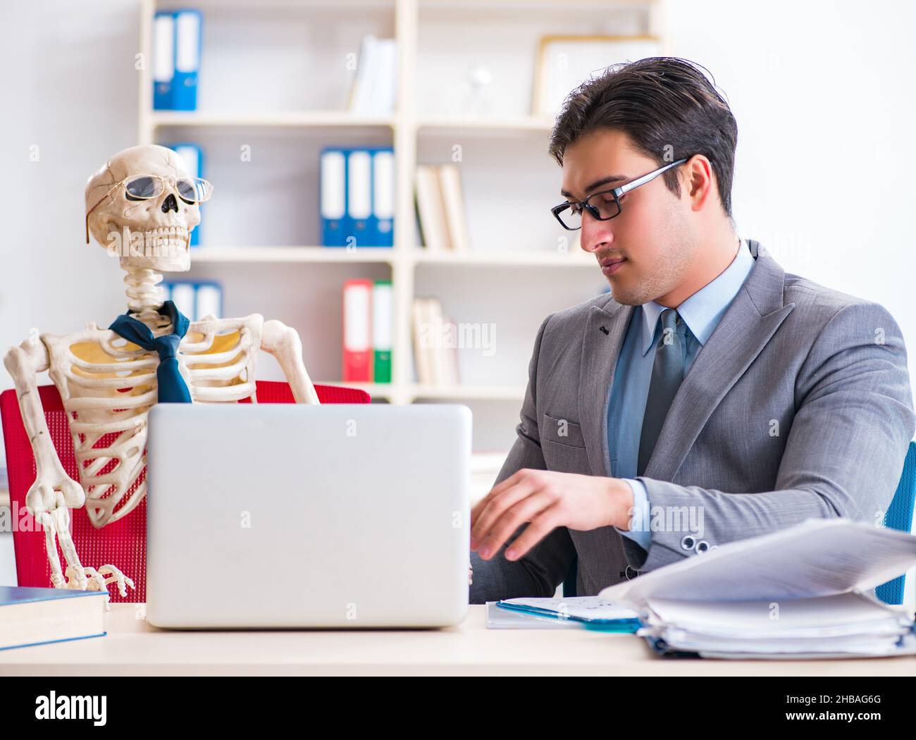 The businessman working with skeleton in office Stock Photo - Alamy