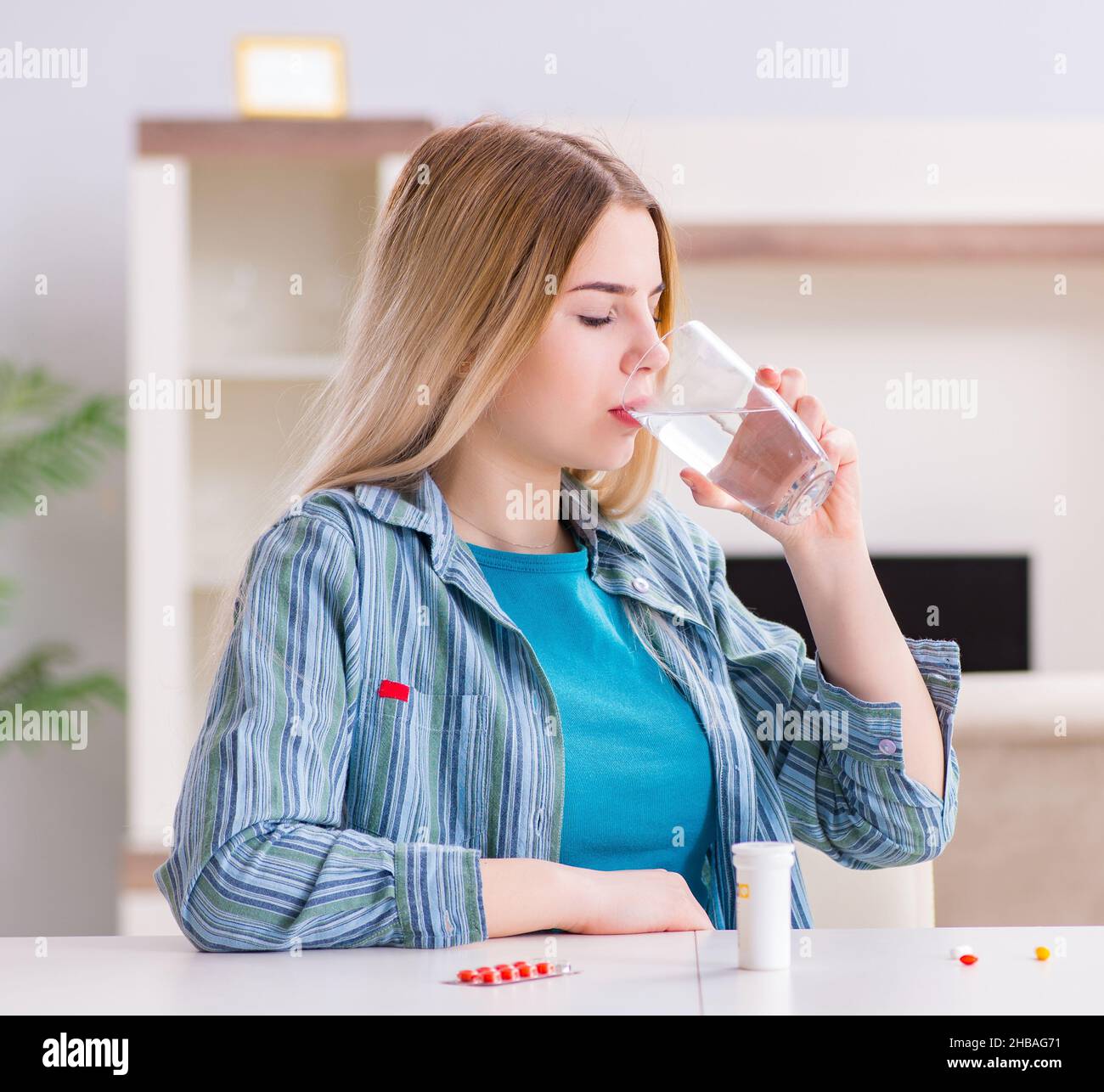 The woman taking pills to cope with pain Stock Photo - Alamy