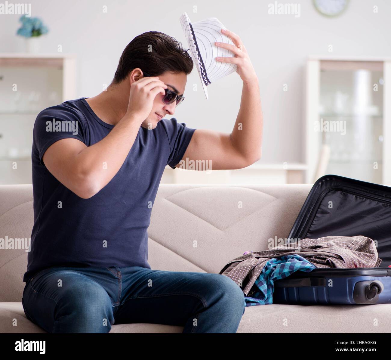 The man going on vacation packing his suitcase Stock Photo - Alamy