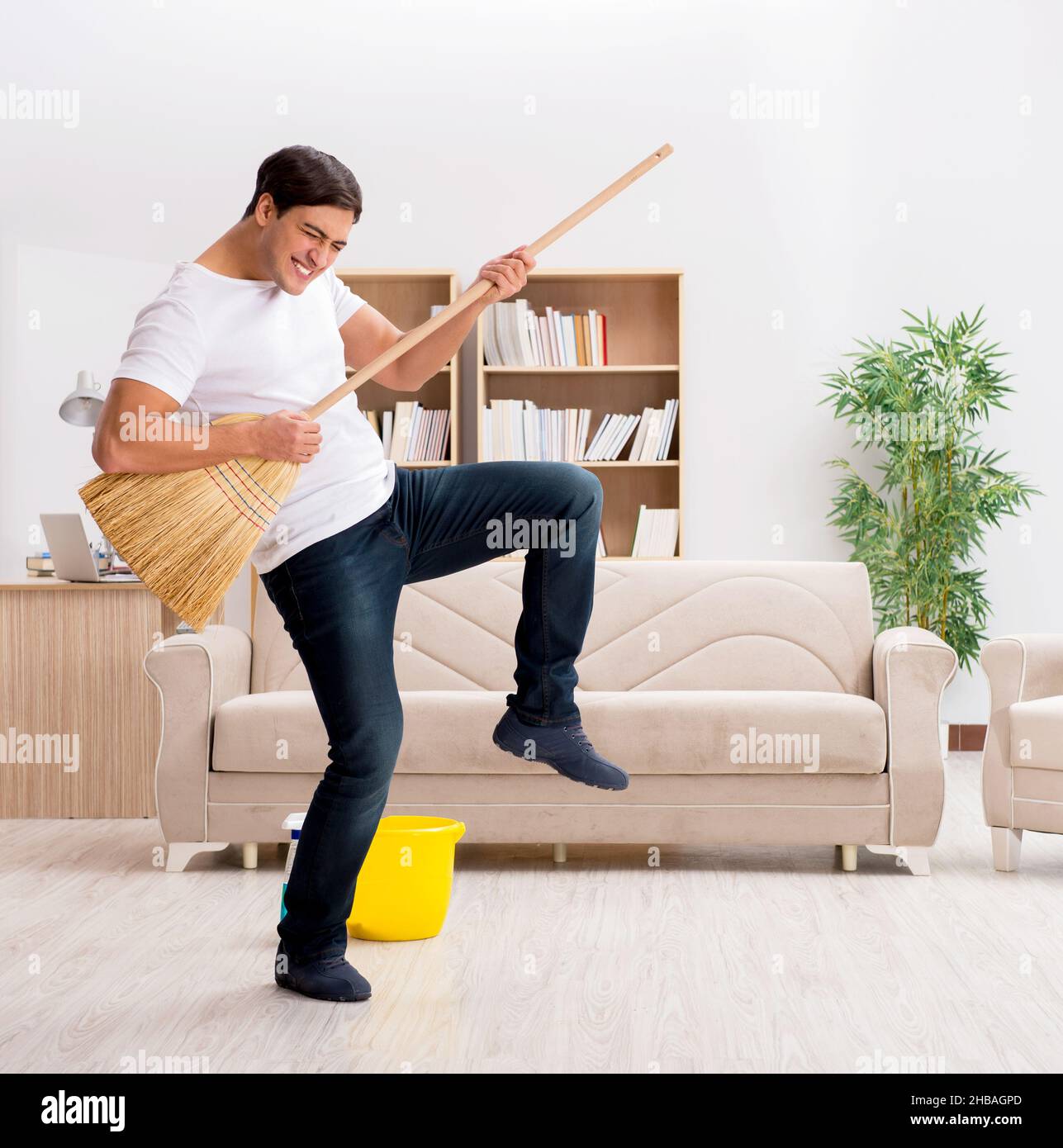 The man cleaning home with broom Stock Photo - Alamy