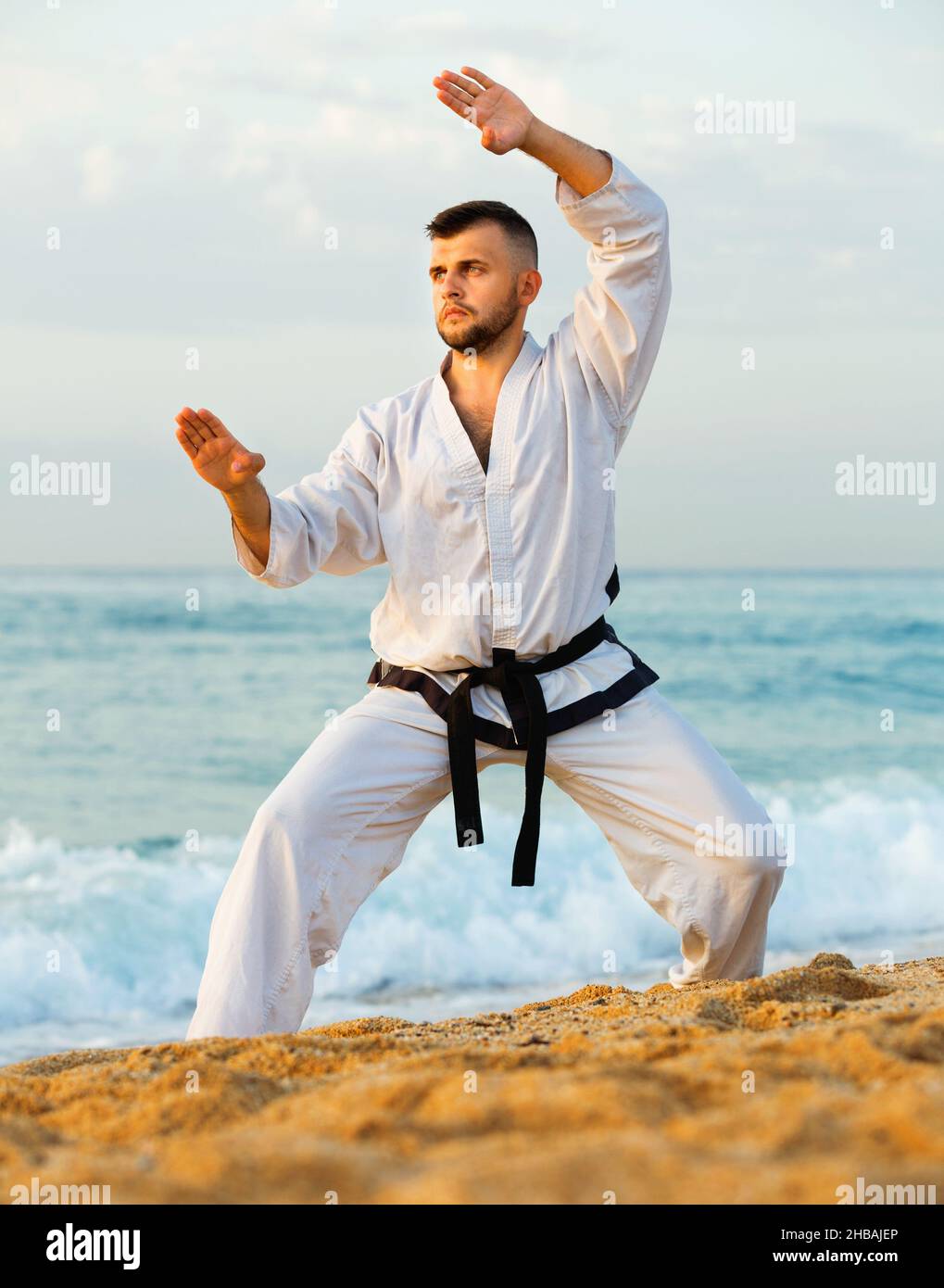 Guy doing karate poses at sunset sea shore Stock Photo - Alamy