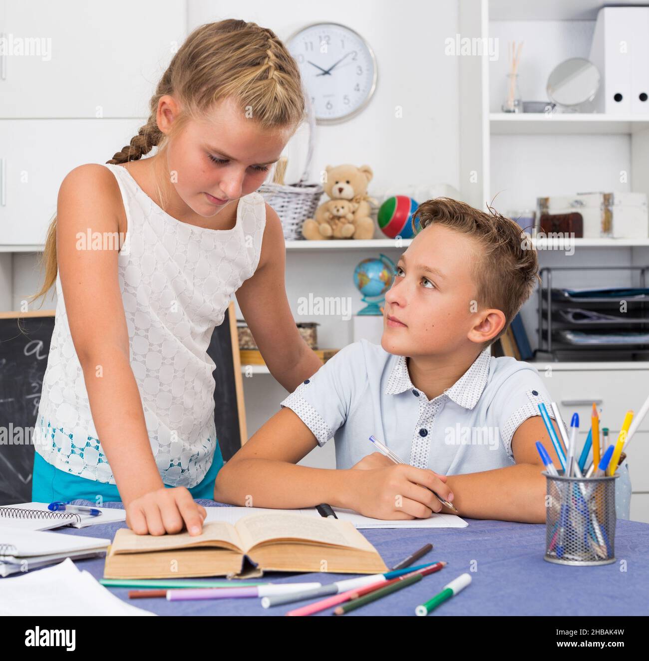 Girl is helping brother doing homework Stock Photo - Alamy