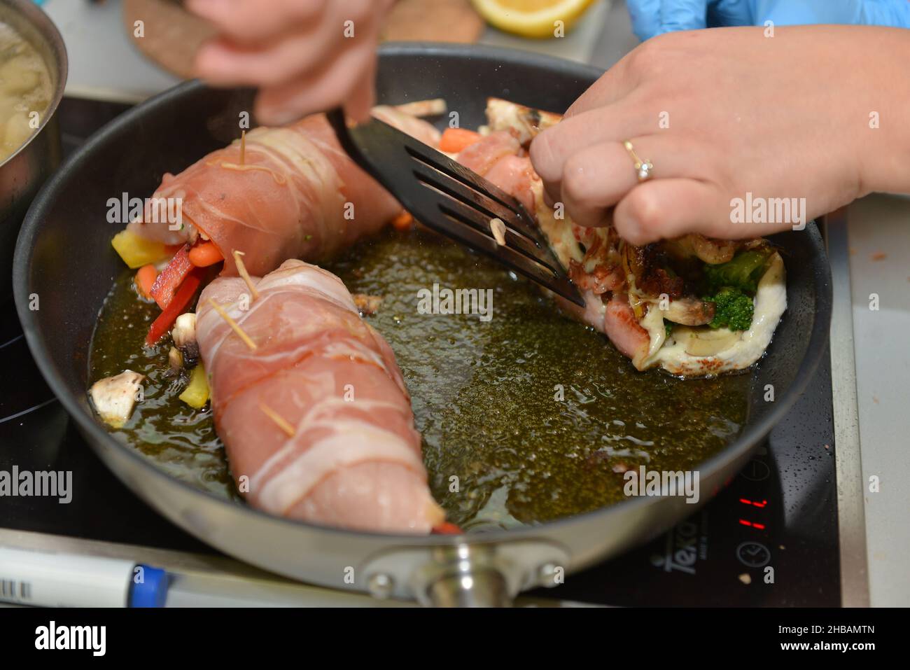 High angle shot of vegetables covered in bacon in a pan Stock Photo - Alamy