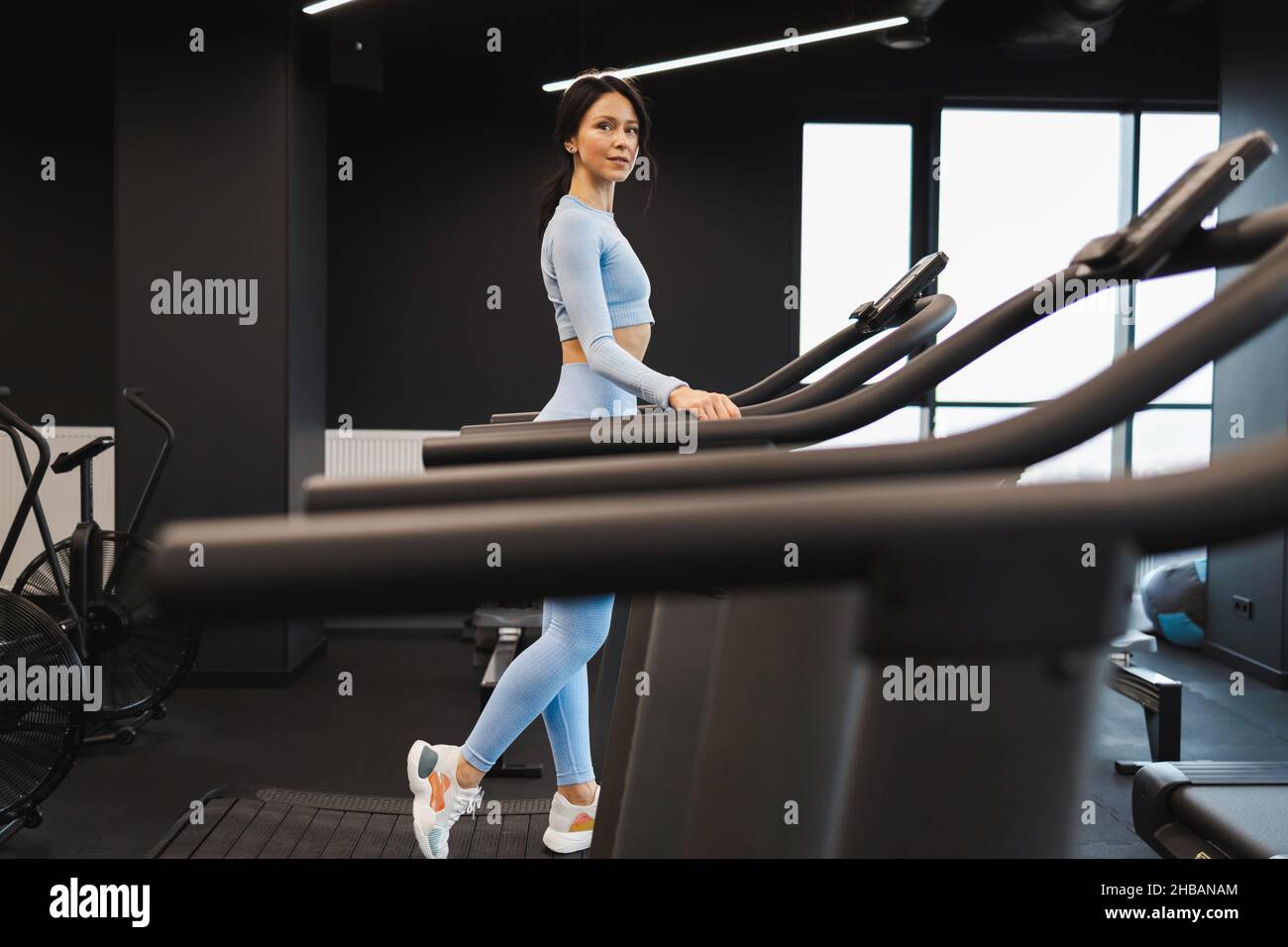 Fitness woman walks on a treadmill Stock Photo - Alamy