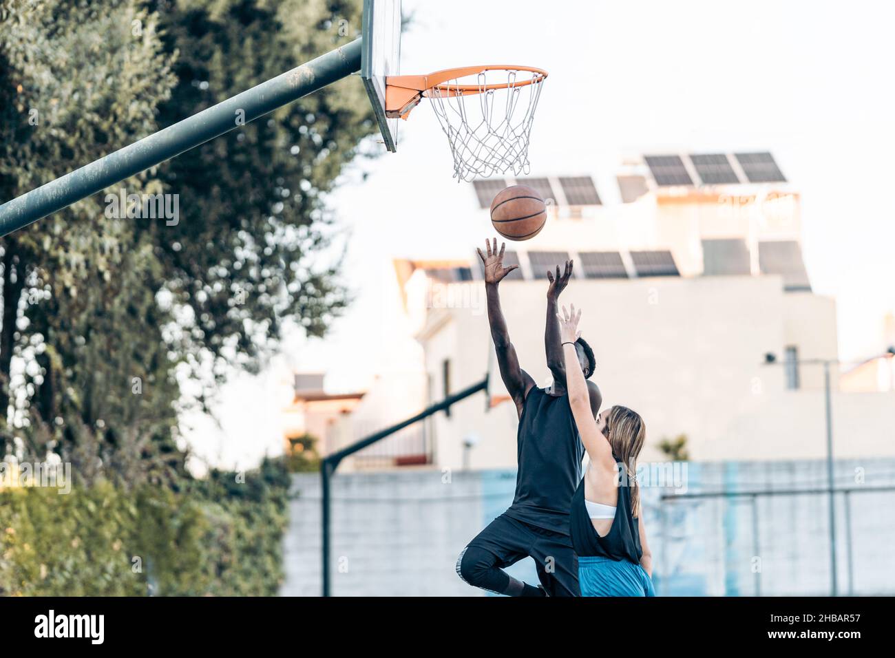 Man jumping to shoot a ball into a basket during a match between ...