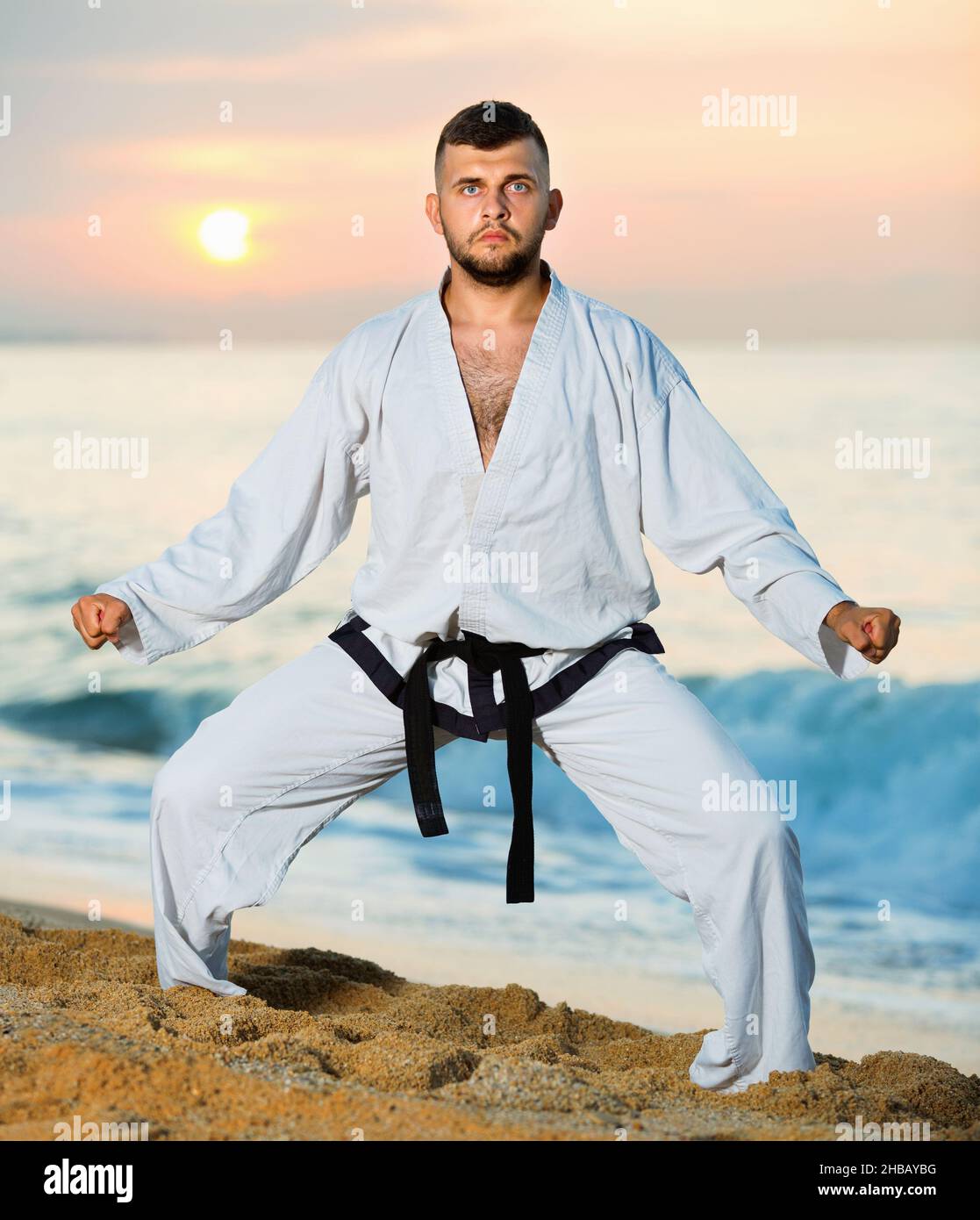 Guy doing karate poses at sunset sea shore Stock Photo - Alamy