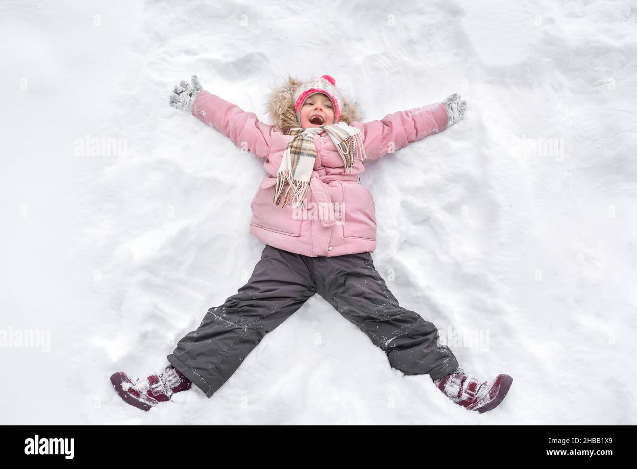 A happy little toothless girl in the winter walk, in the nature. A ...